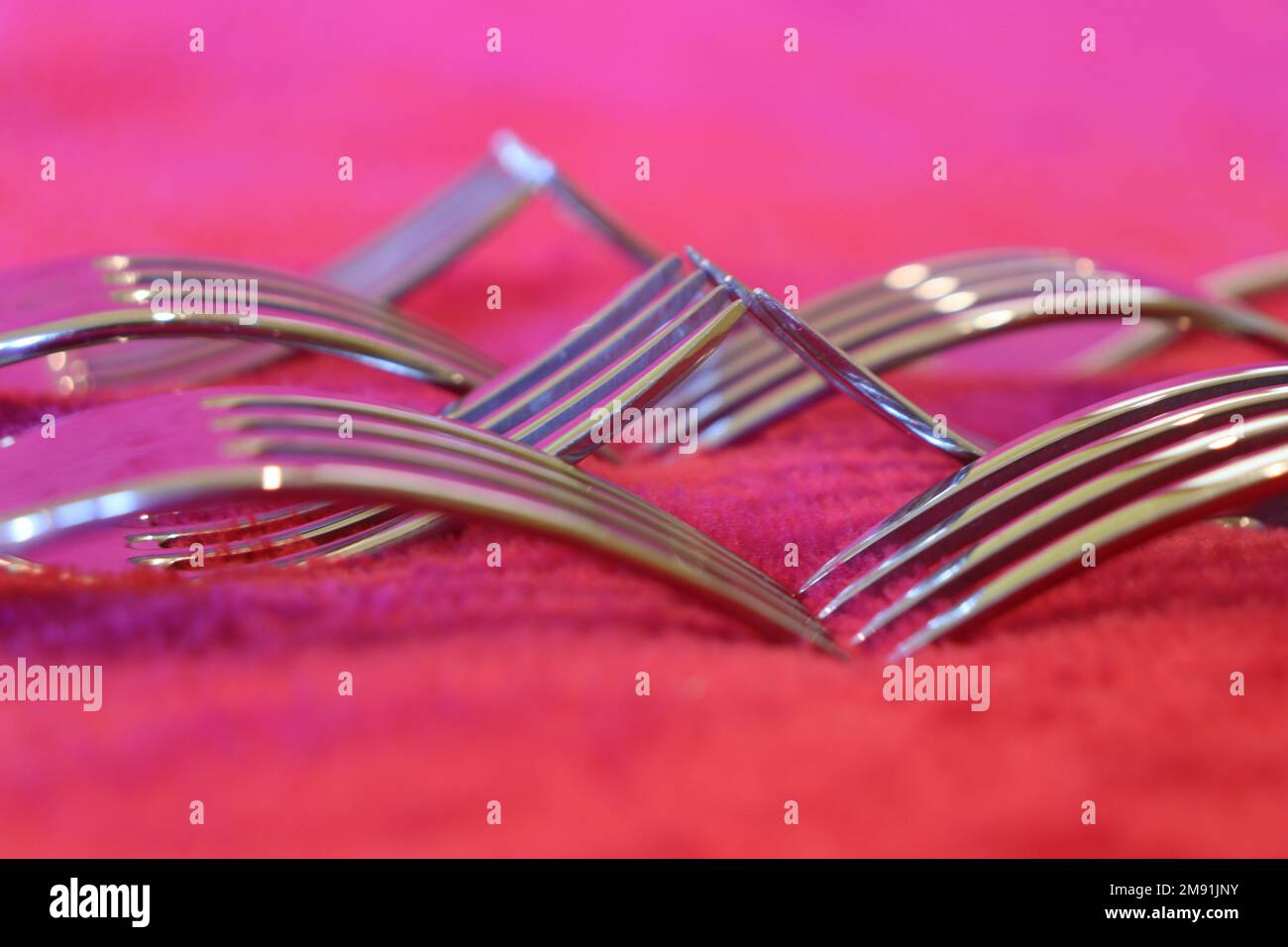 Forks on red background Stock Photo - Alamy