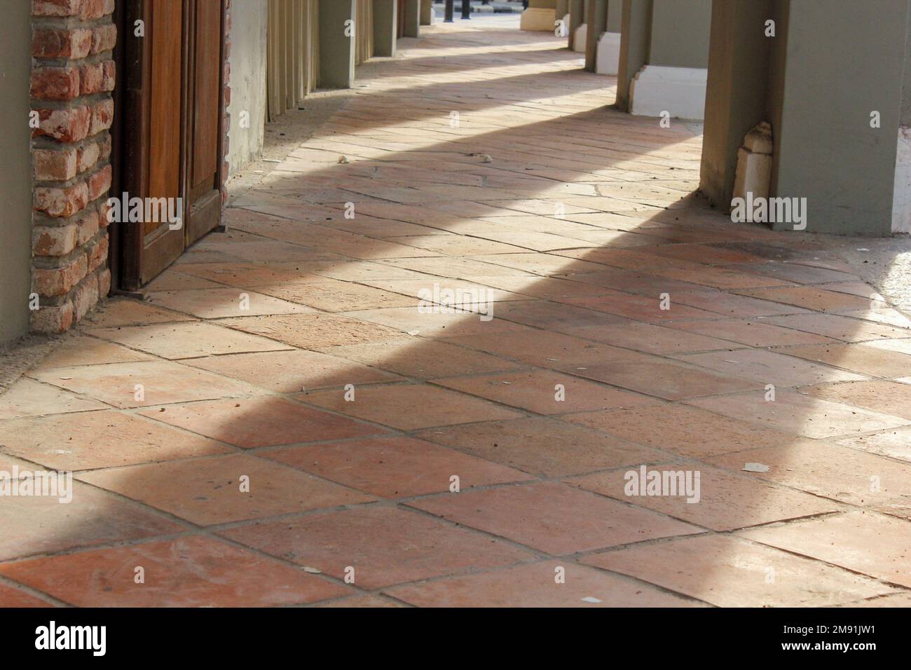 Detail of shadows of old colonial columns in a pavement alley in the ...
