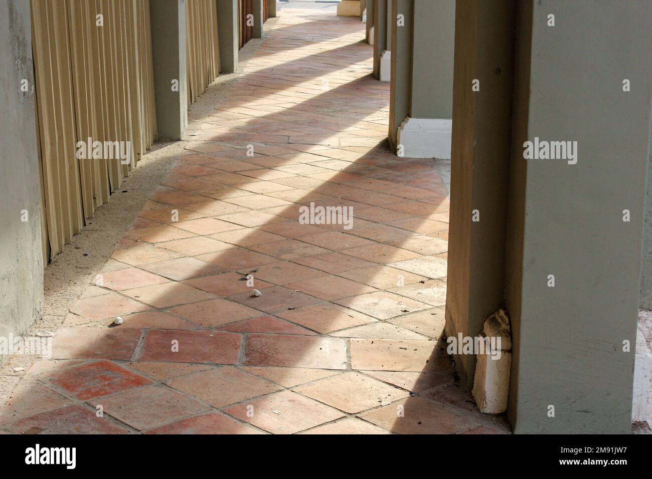 Detail of shadows of old colonial columns in a pavement alley in the ...