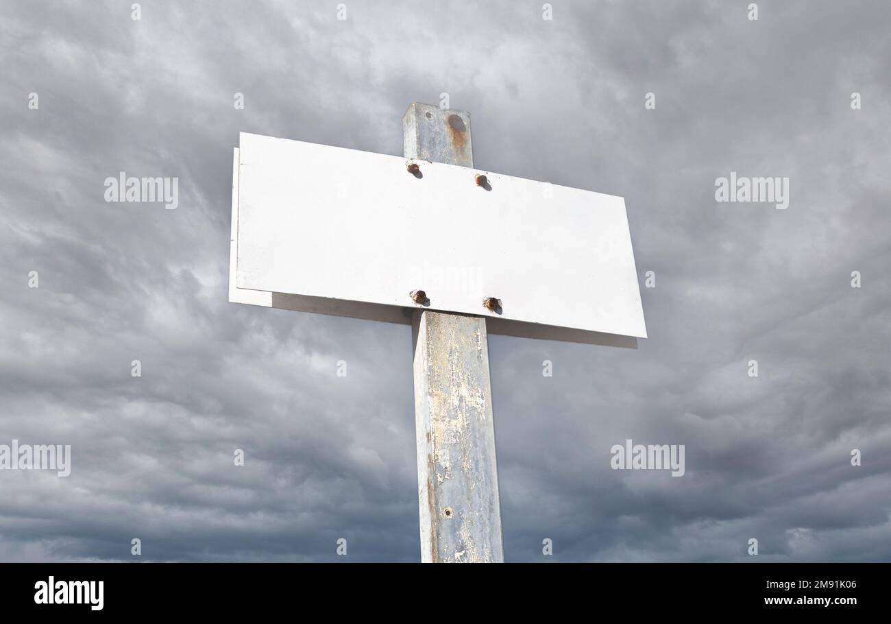 Blank white aged sign on stormy sky background. Weathered metallic post ...