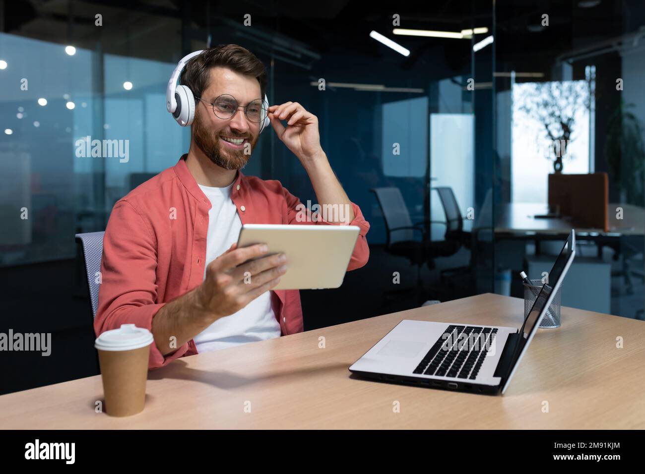 Successful businessman at workplace smiling man watching online video sitting at desk wearing ...