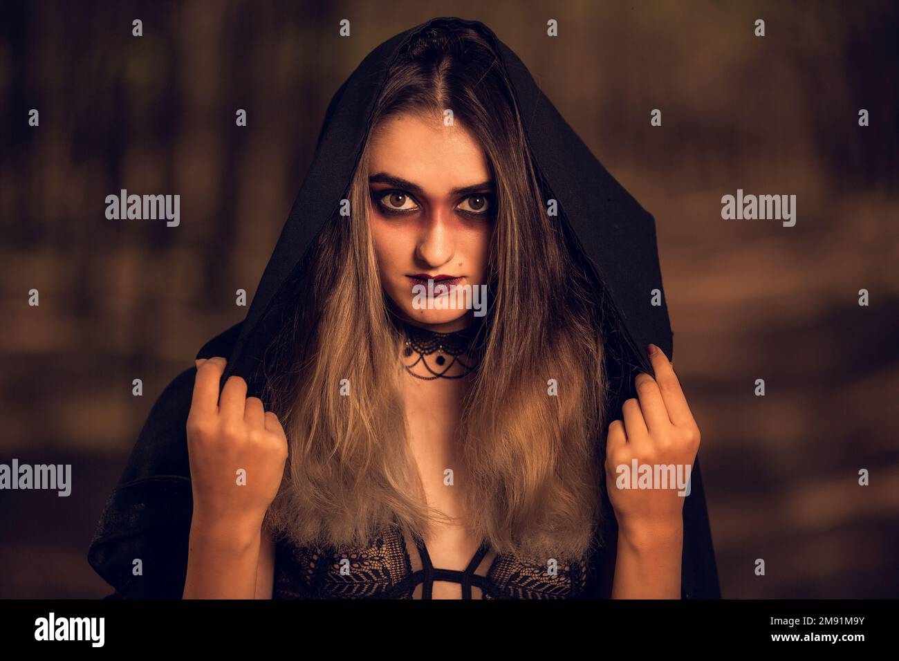 A close-up shot of a gothic girl with black cape looking at the camera ...