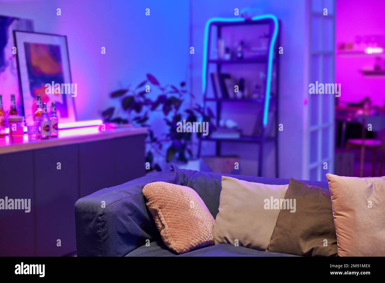 Part of spacious neon lit living room with comfortable couch with beige ...