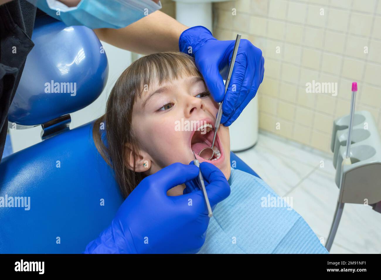 A male dentist is examining a child patients teeth Stock Photo - Alamy