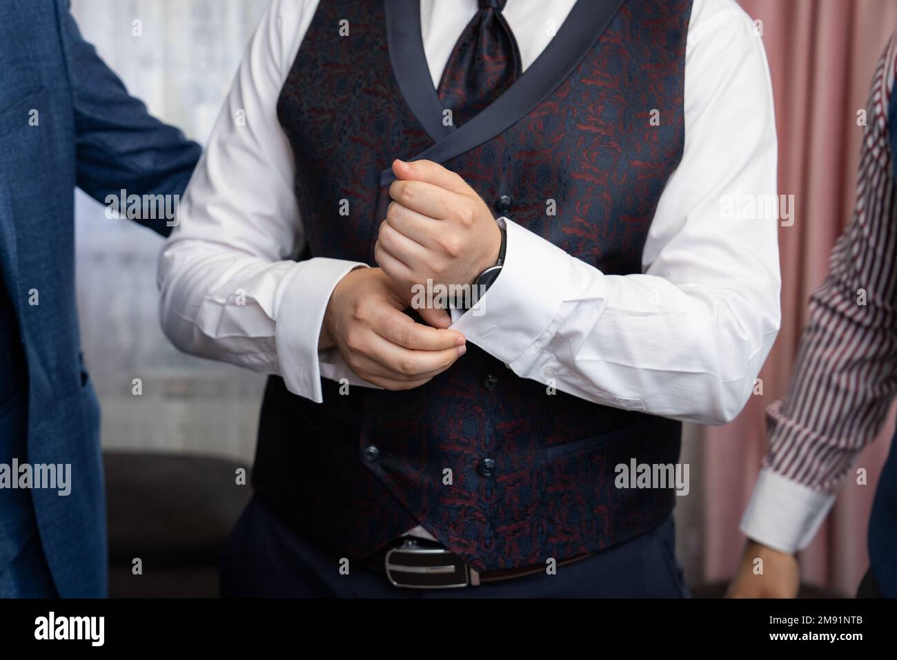 A groom buttoning his suit hand buttons Stock Photo - Alamy