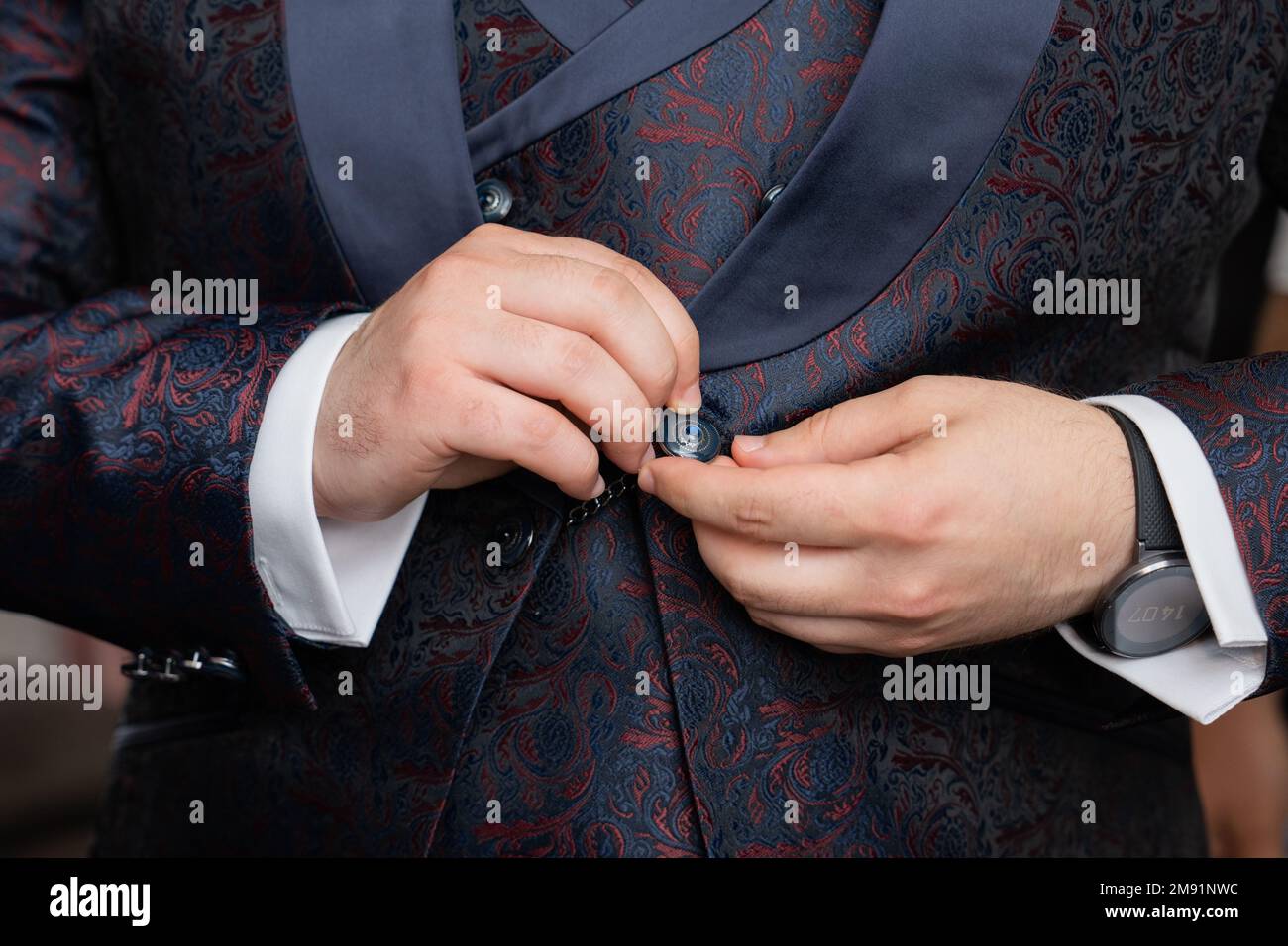 A groom buttoning his suit buttons Stock Photo - Alamy