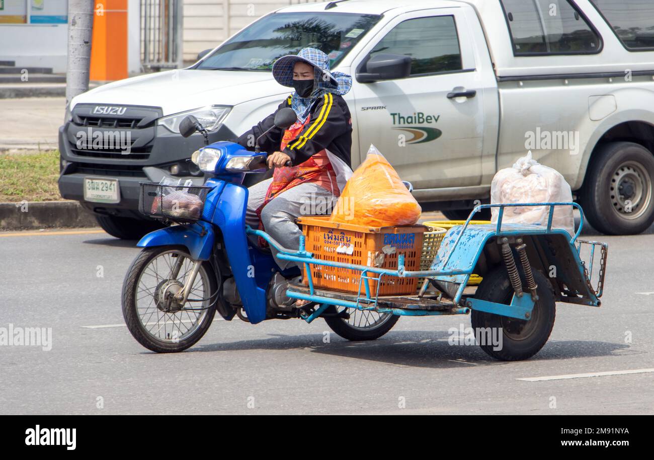 RATCHABURI, THAILAND, NOV 16 2022, A woman rides a motorcycle with a ...