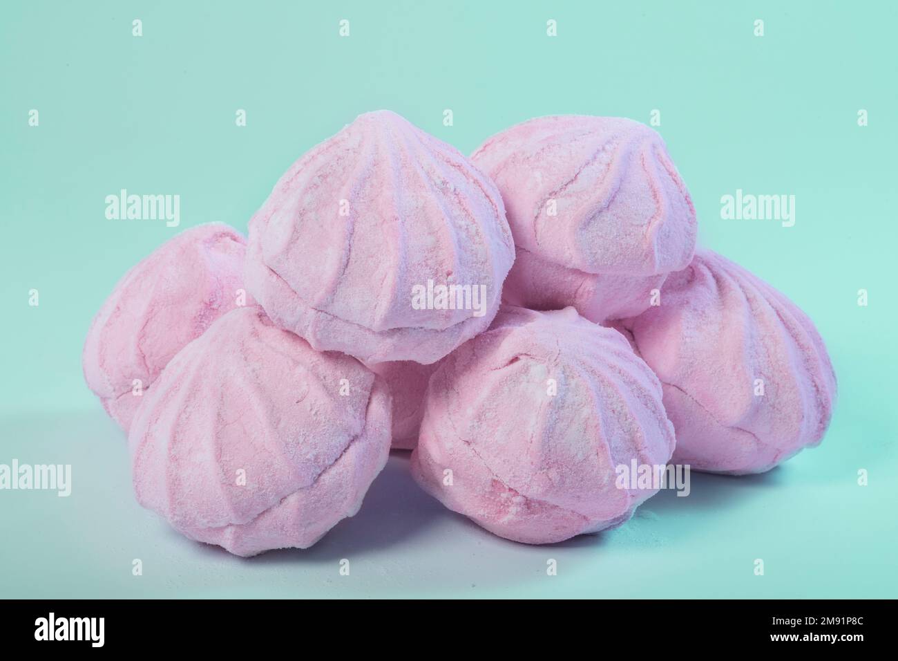 Fresh pink zephyr on a green background. sweets Stock Photo - Alamy