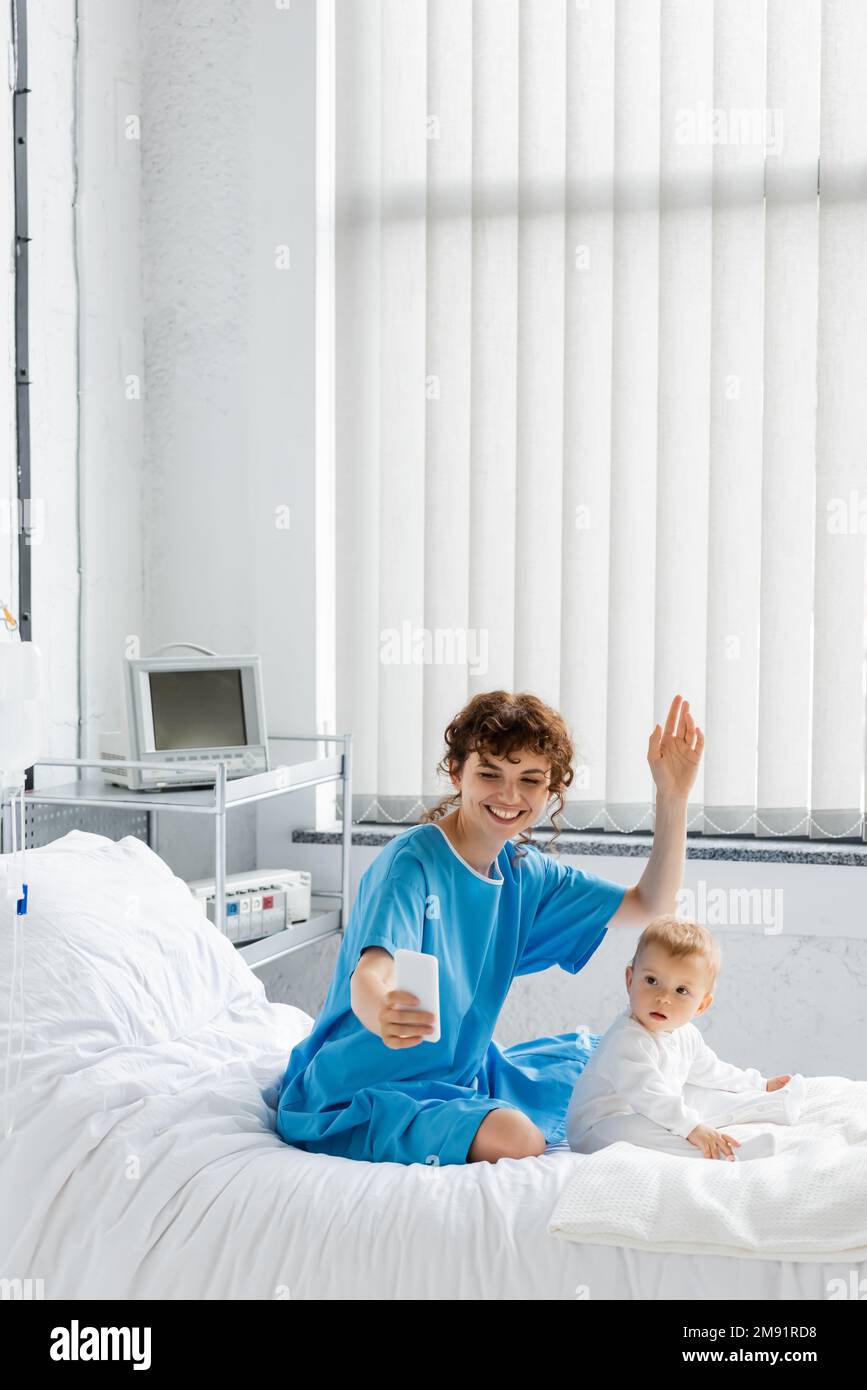 Happy baby smiling and waving hand bed hi-res stock photography and ...