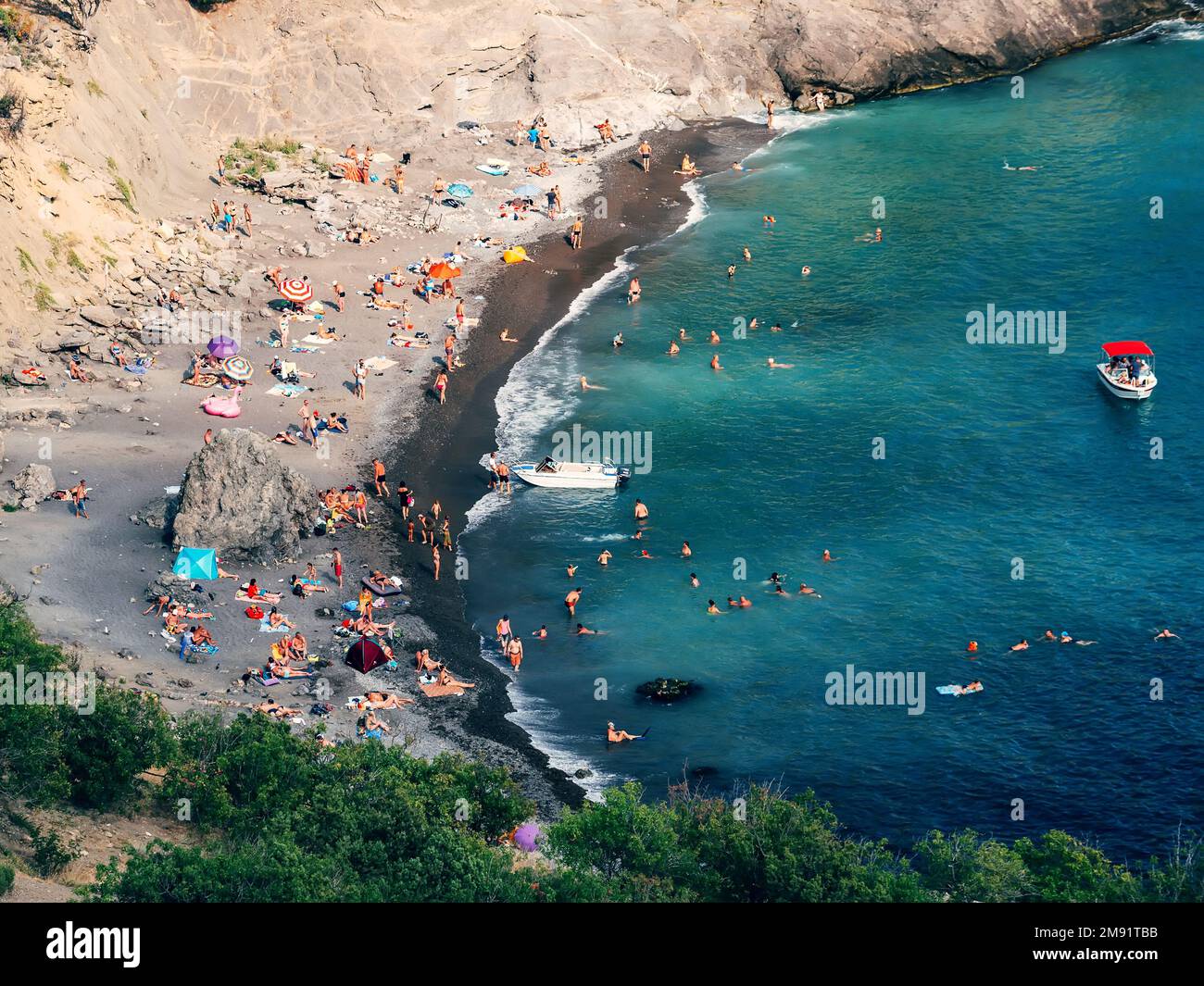 people relax, sunbathe and swim in the sea on the sandy beach top view ...
