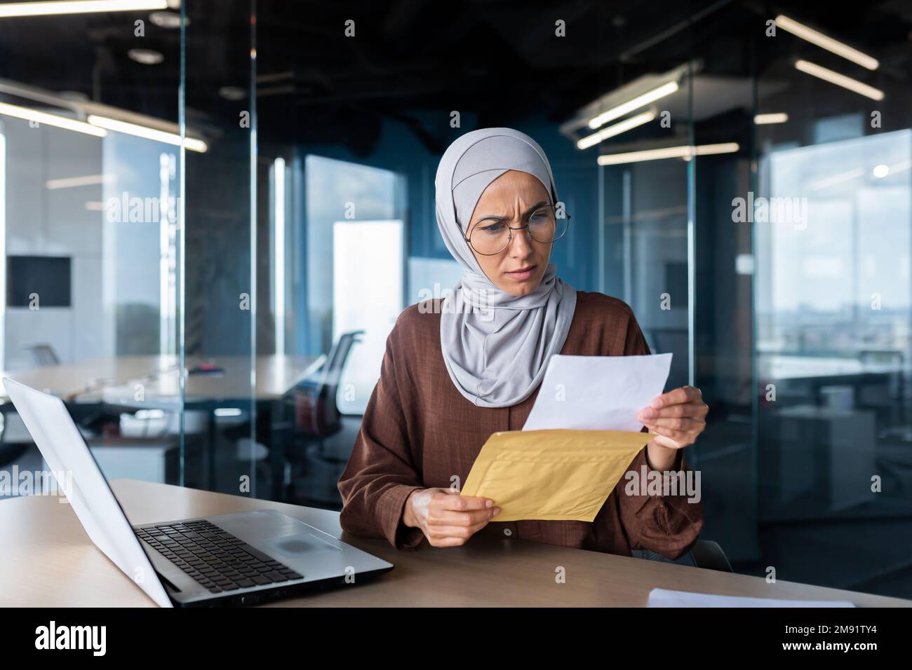 Upset business woman in hijab working inside office, woman received ...