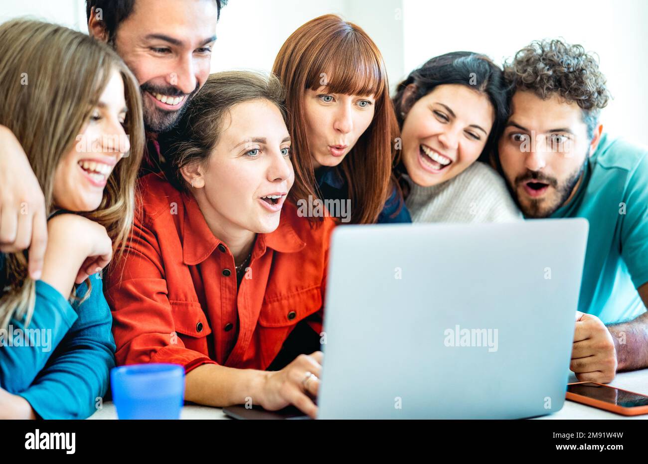 Happy genz employee friends having surprised fun together on laptop pc ...