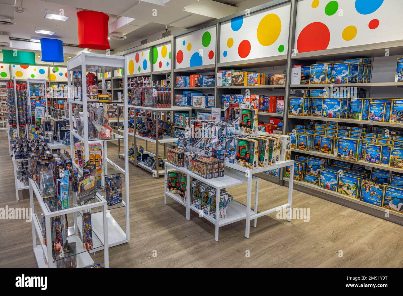 Colorful interior of Macy's toy department. Rack with various boxes of ...