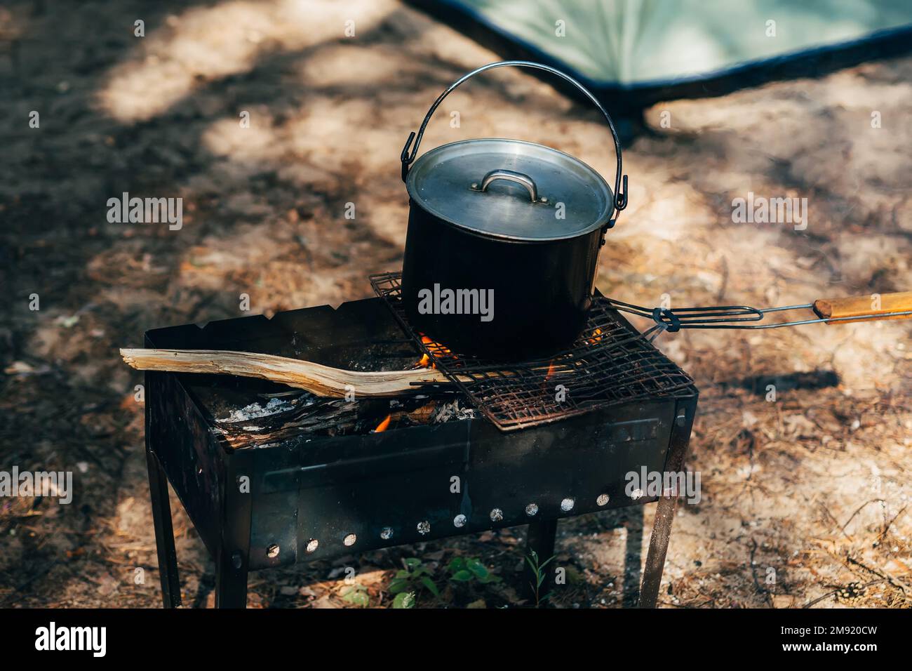 metal pot of food heated on a fire camping trip on summer vacation ...