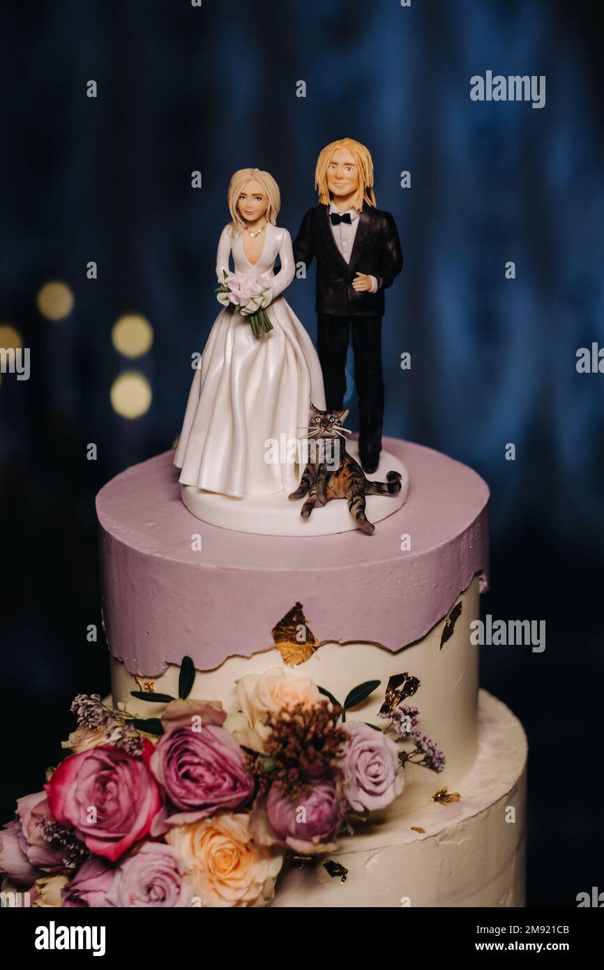 Three-level wedding cake with figures of people on it Stock Photo - Alamy