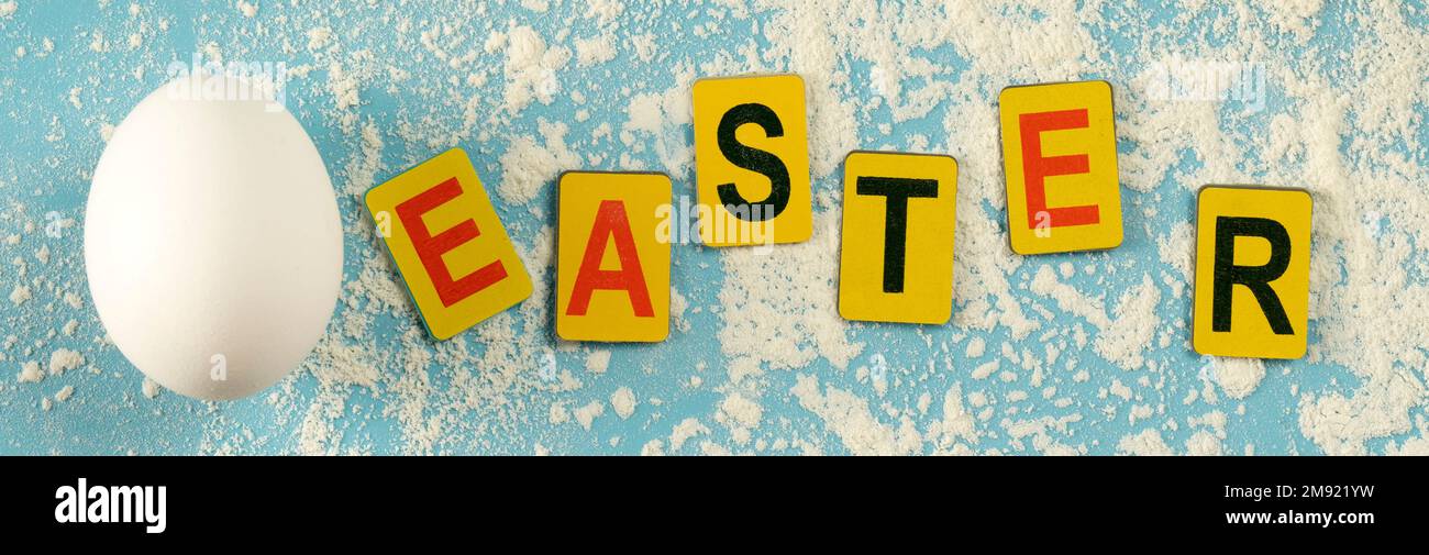 Multicolored letters arranged in the word "Easter" on a blue background ...