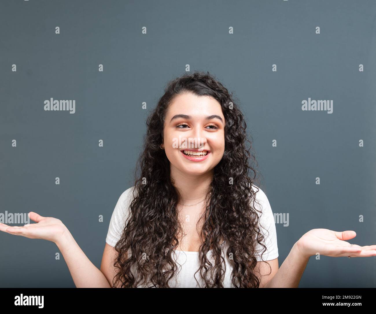 Cheerful young beautiful woman asking, with arms gestures, what happens ...