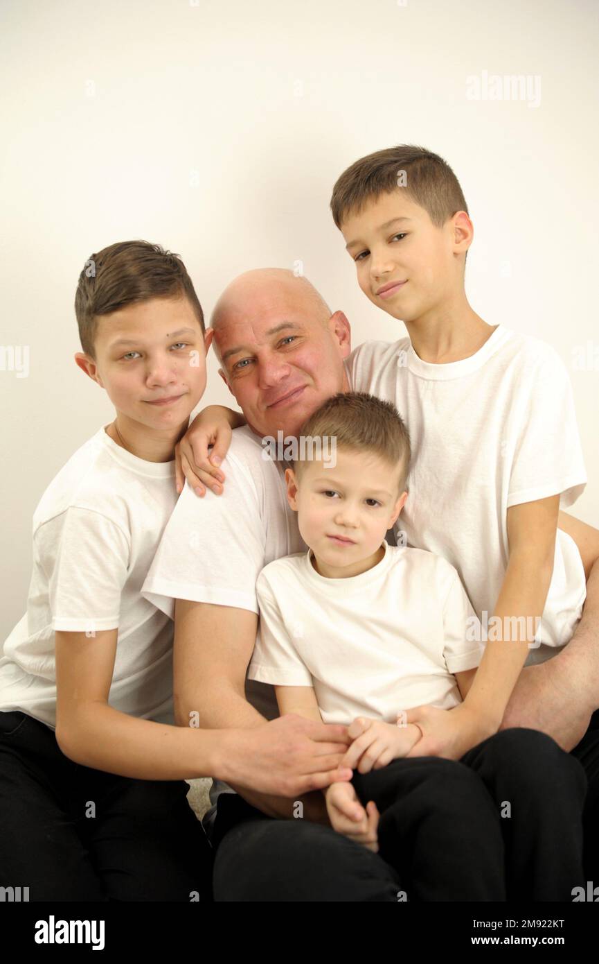 photo of father three sons children stuck around dad from all sides it ...