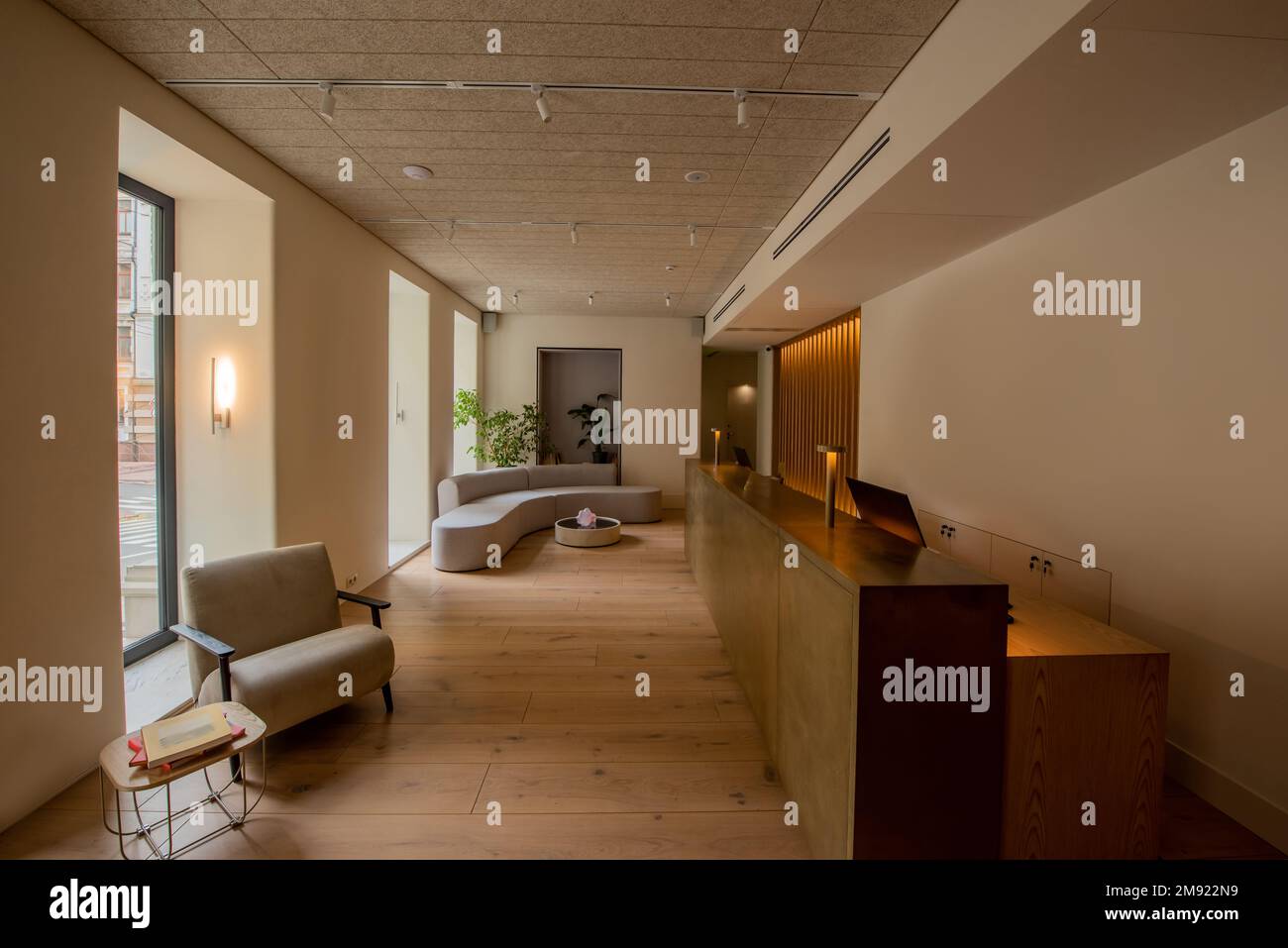 interior of luxury hotel lobby with reception desk near modern sofa and ...
