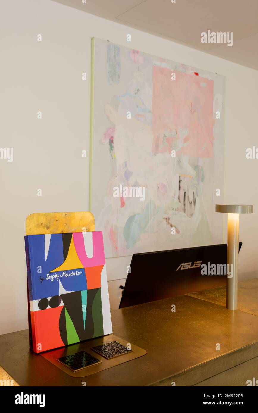 abstract painting on wall near reception desk with art book and ...