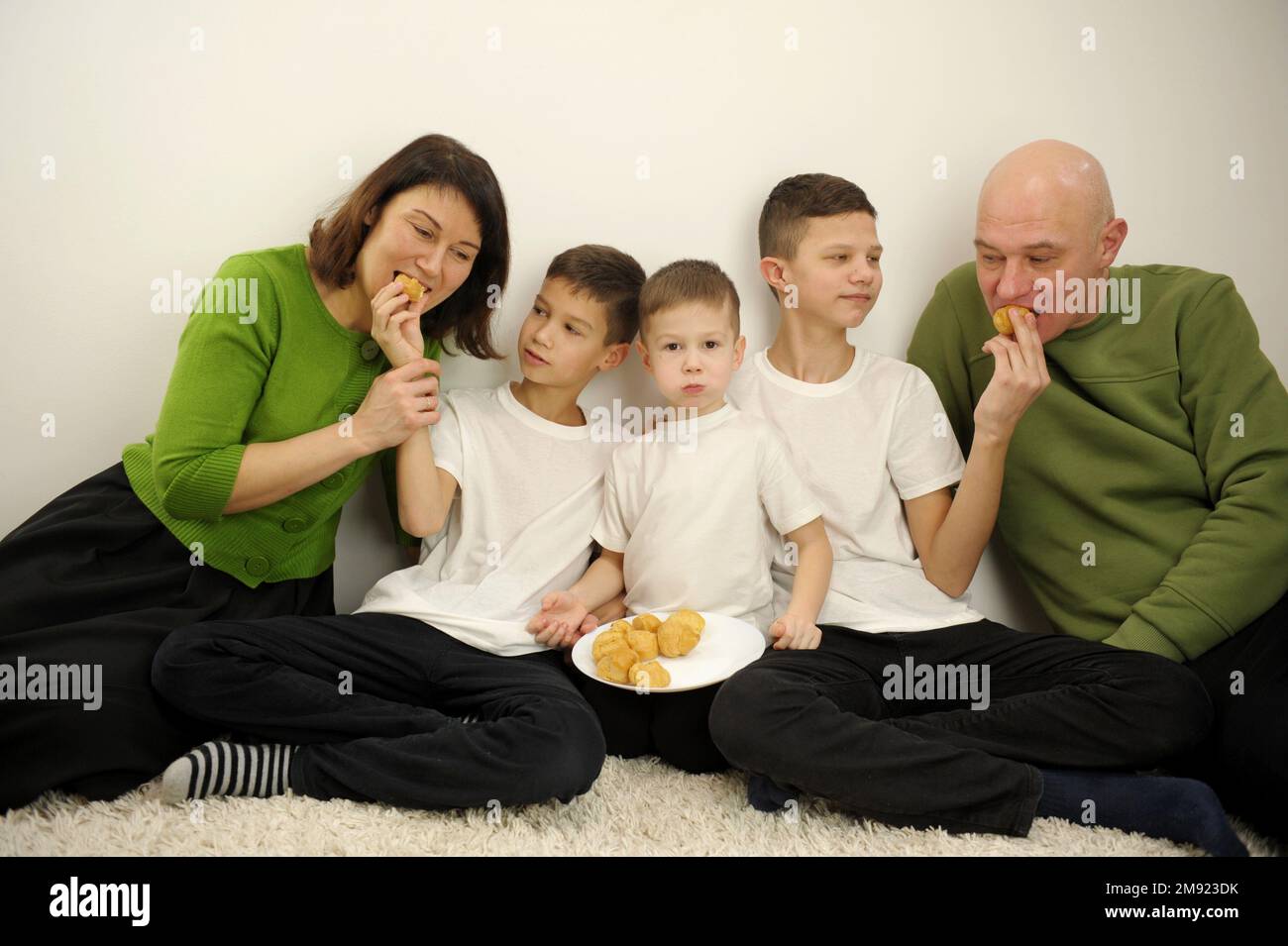 happy cheerful family eating custards together they opened their mouths ...