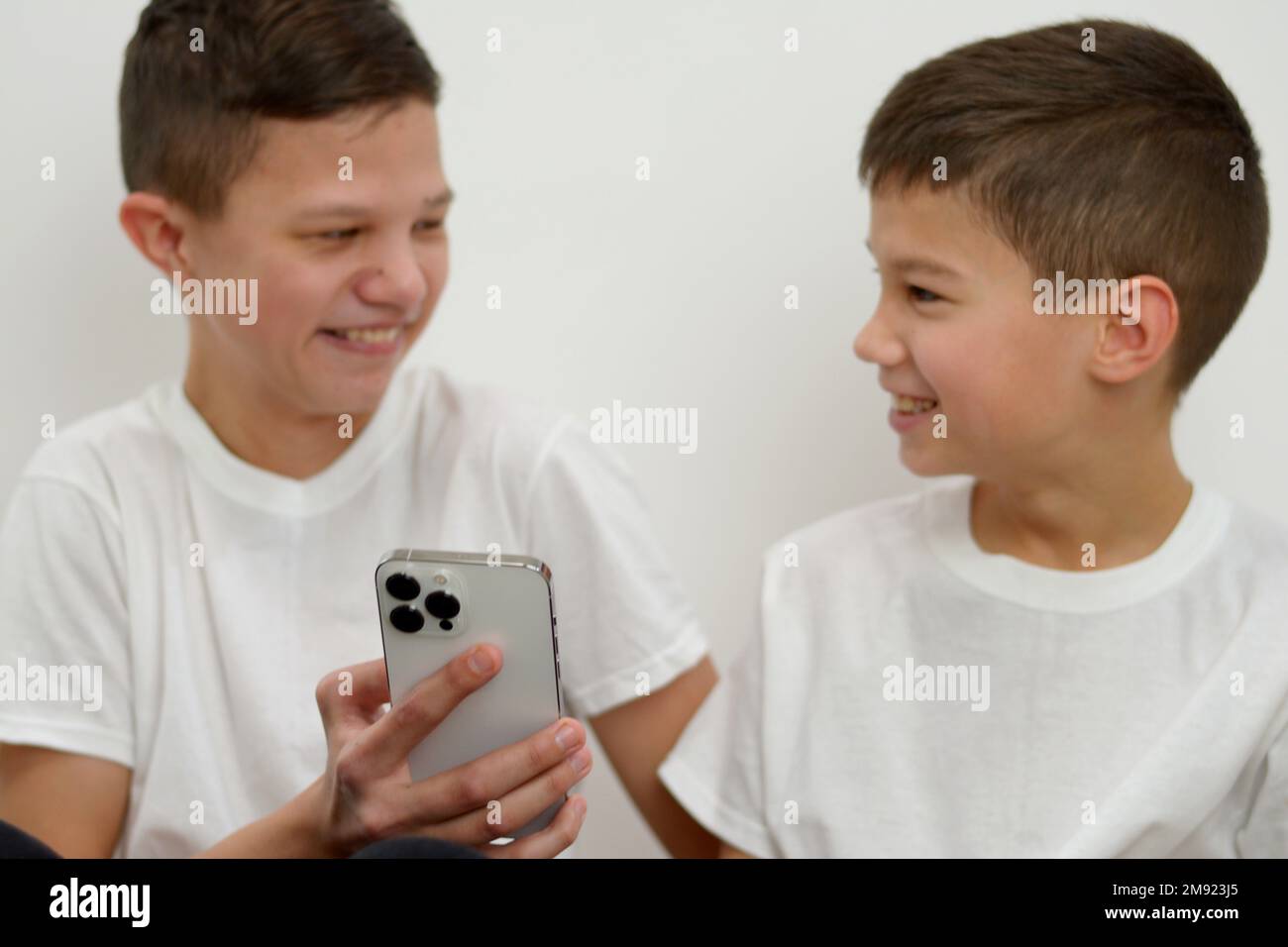 Two attractive teenagers sitting look to phone Smiling laughing ...