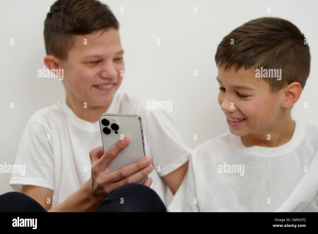 Two attractive teenagers sitting look to phone Smiling laughing ...
