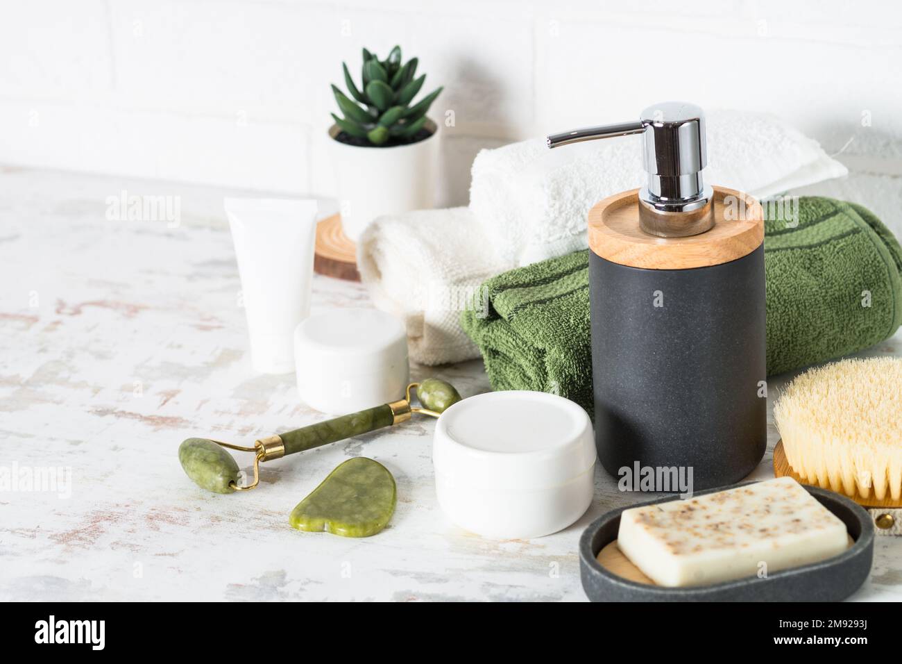 Bath accessories in the bathroom. Bottle of soap, cream, jade roller ...