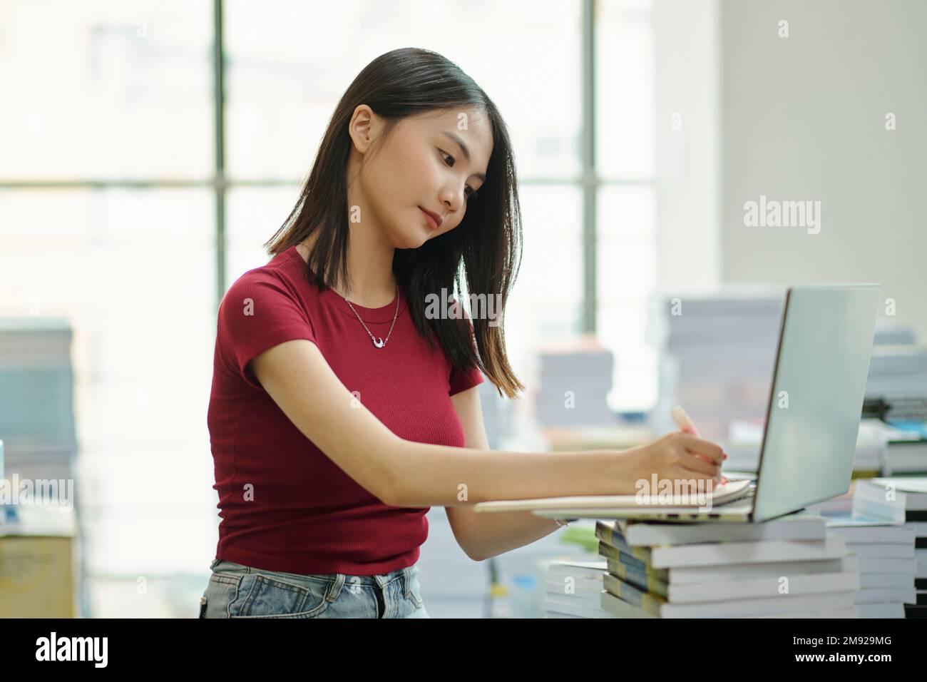 High school student doing homework in library Stock Photo - Alamy