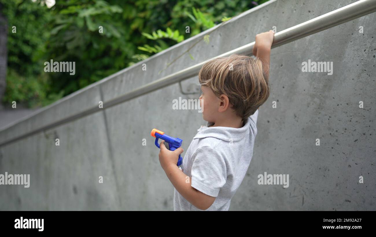 Child walking down stais holding handrail Stock Photo - Alamy