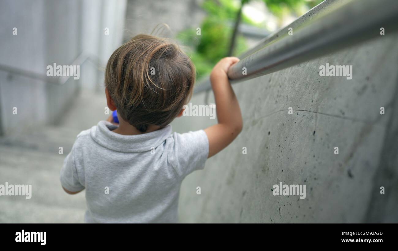 Child walking down stais holding handrail2 Stock Photo - Alamy