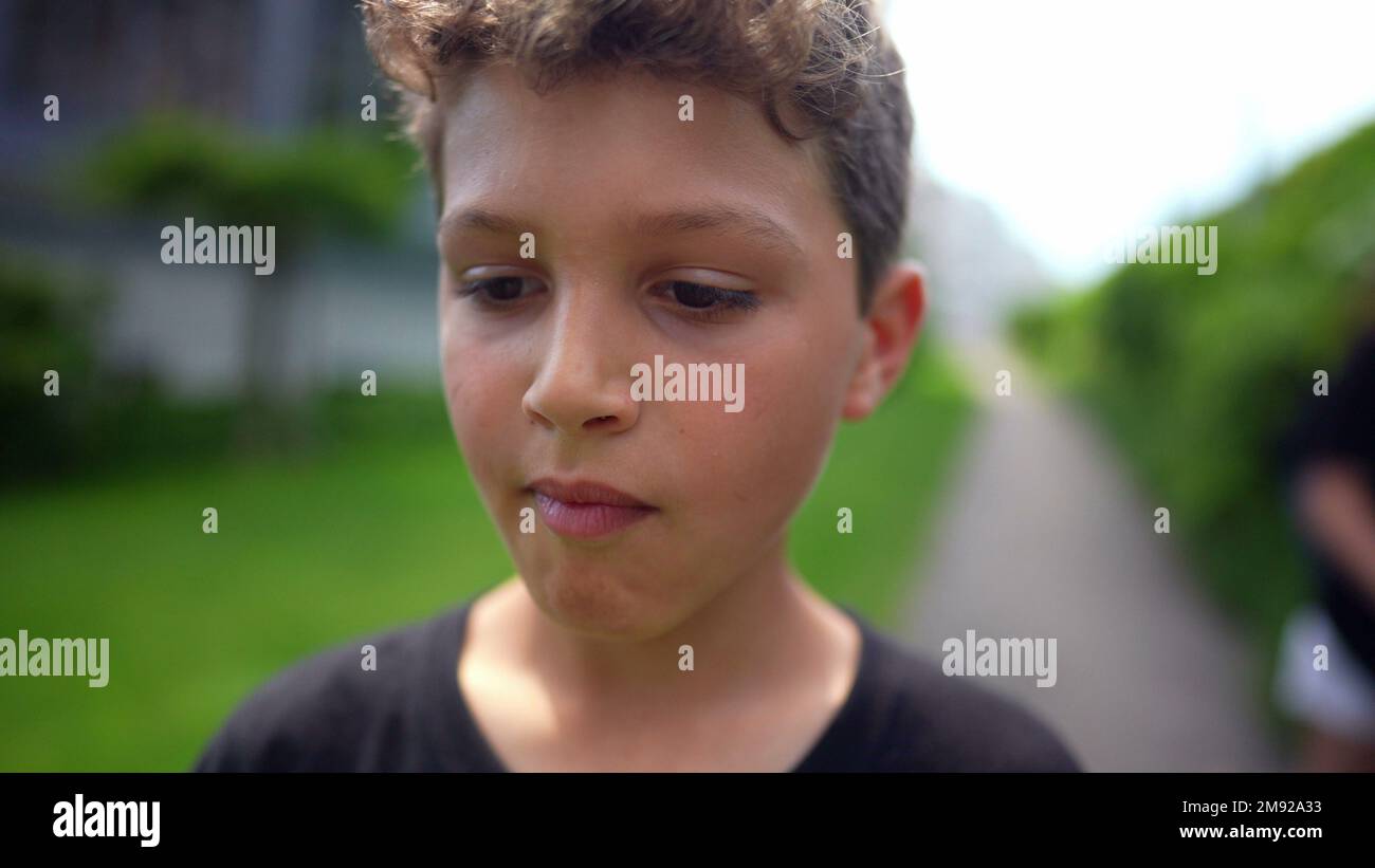 Child walking outside in slow-motion. Pensive thinking boy Stock Photo ...