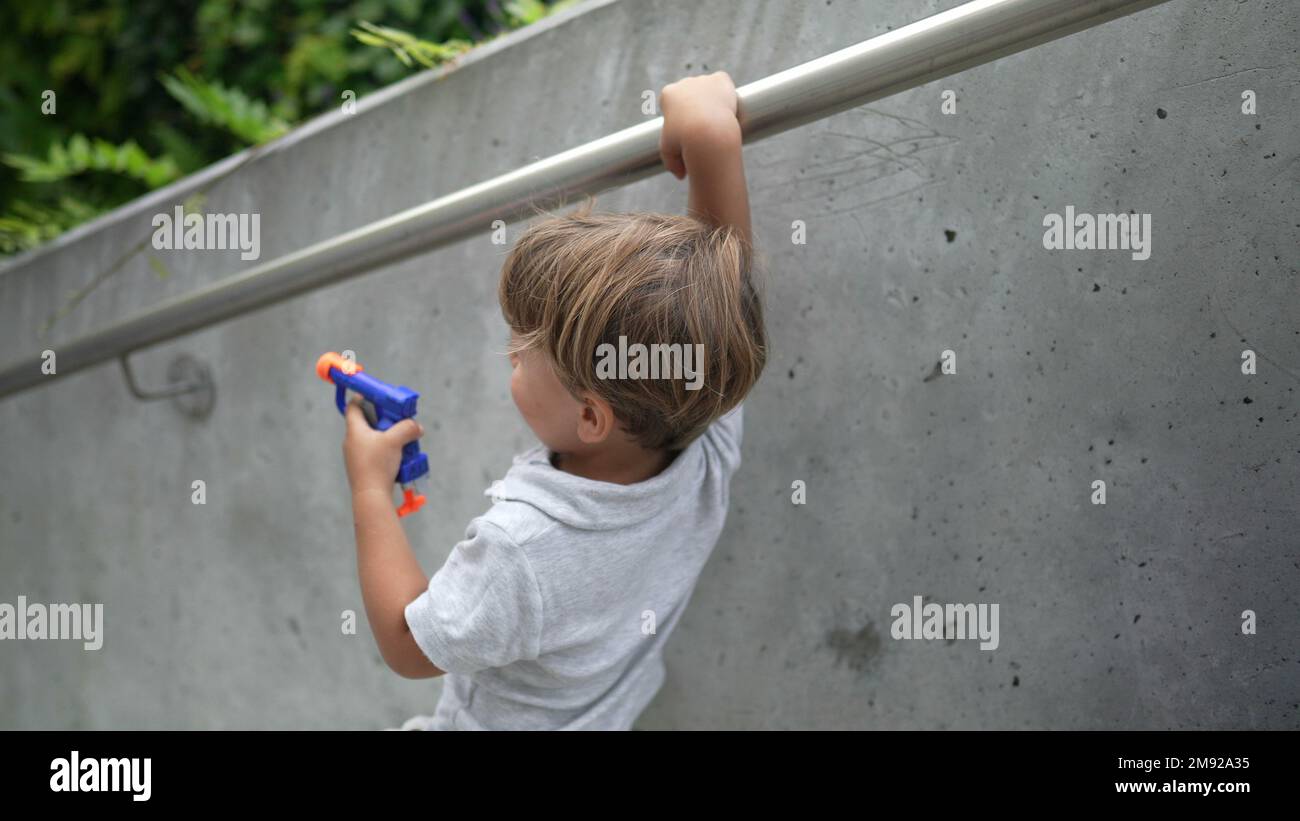 Child walking down stais holding handrail Stock Photo - Alamy