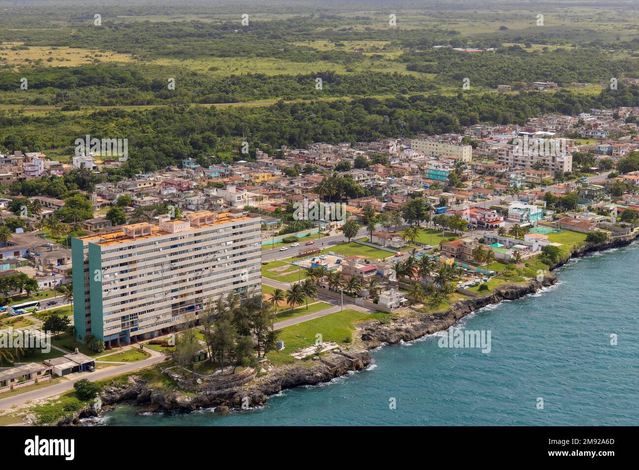 An aerial shot of the beach shore with architecture and forests in the ...