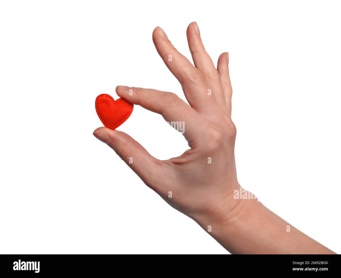 A woman's hand holds a small red heart with her fingers Stock Photo - Alamy