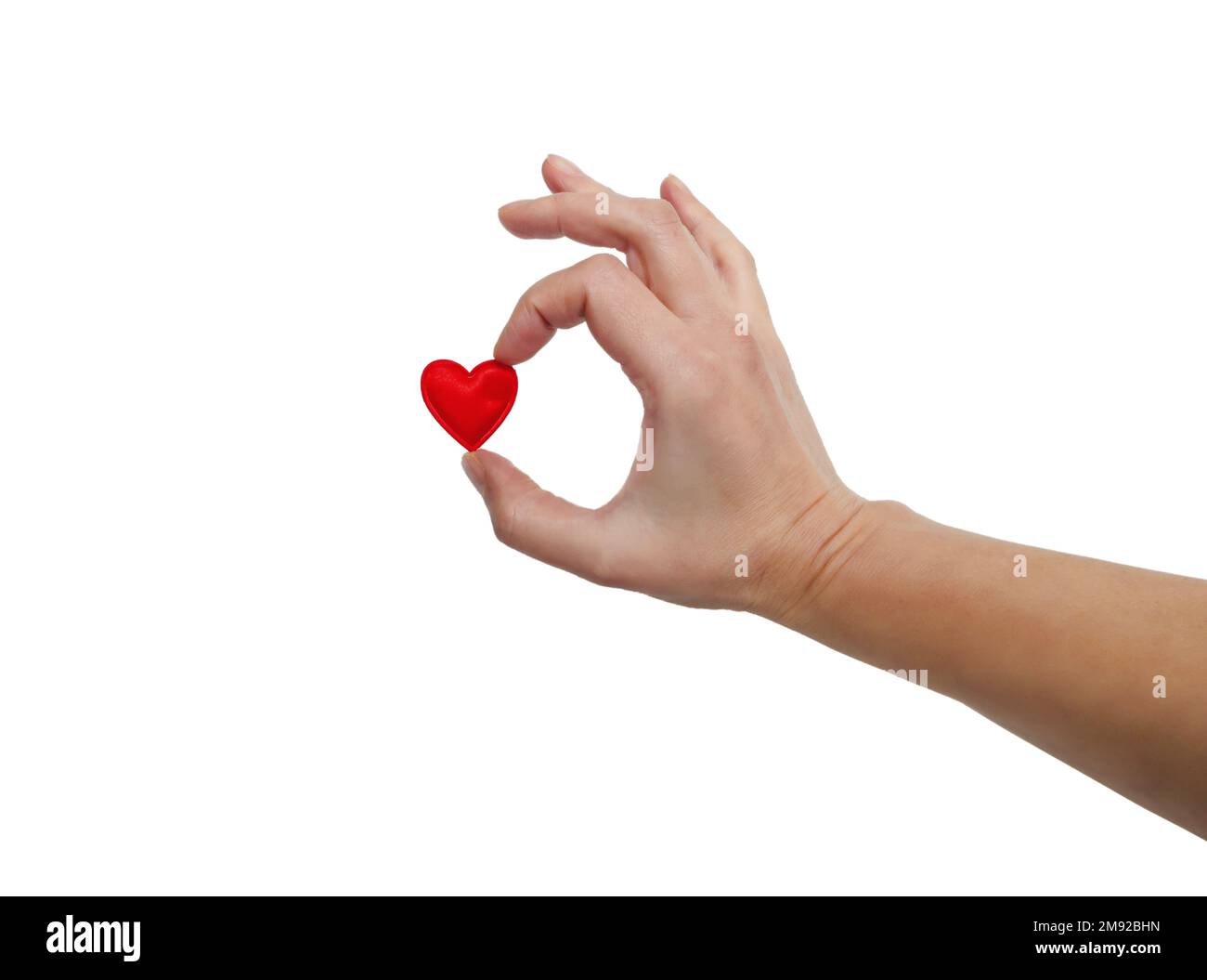 A woman's hand holds a small red heart with her fingers Stock Photo - Alamy