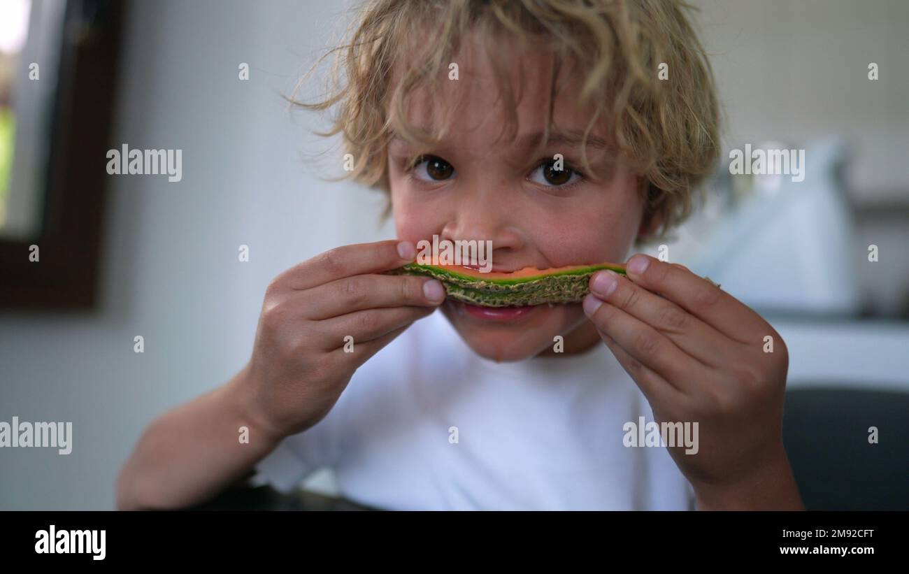 Child eating melon fruit. Portrait kid eating healthy food Stock Photo ...