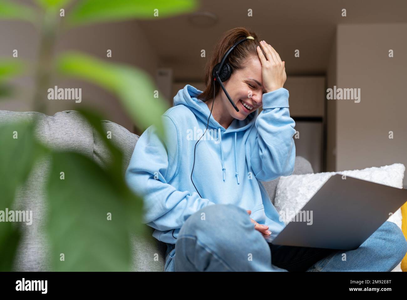 Young woman student in headset studying online course using laptop and ...