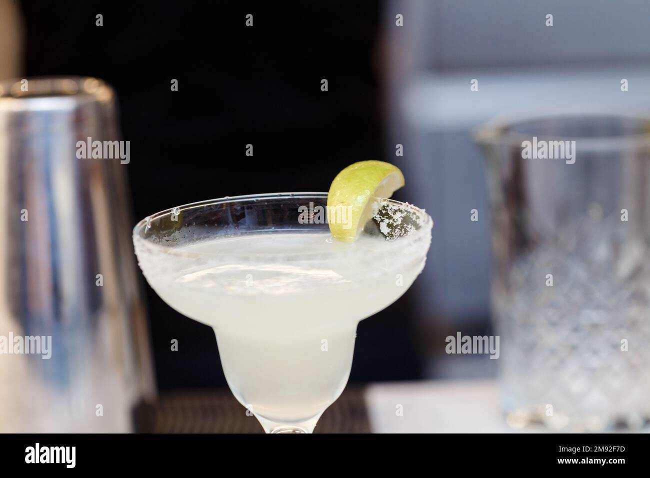 The process of making a pink cocktail with ice on a bar table. High ...