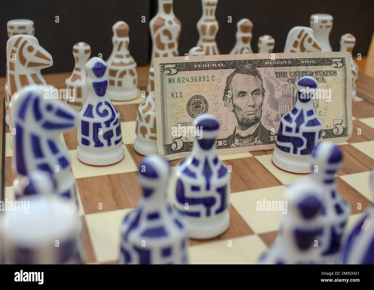 a five dollar bill on the chessboard Stock Photo - Alamy