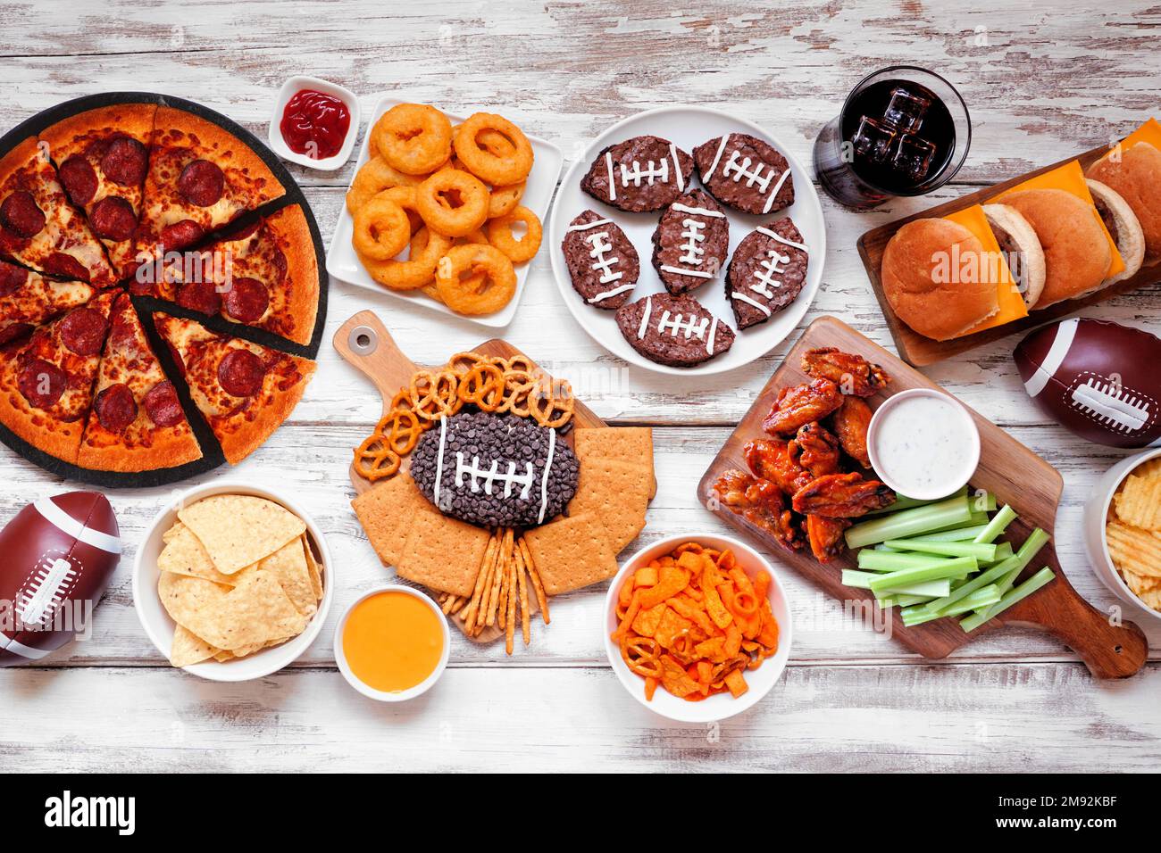 Superbowl or football theme food table scene. Pizza, hamburgers, wings ...