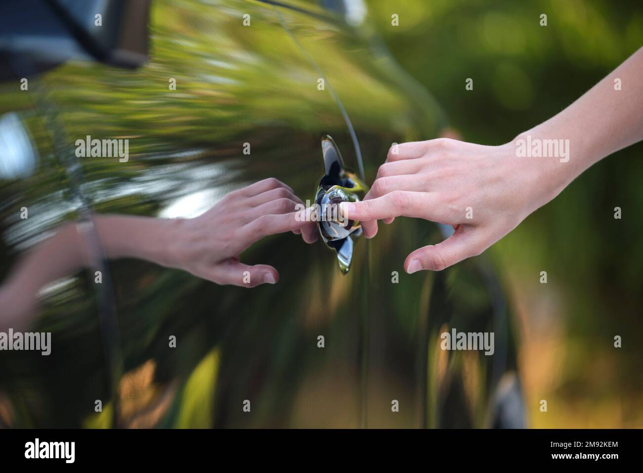 Closeup of driver hand opening car front door with touch ID finger ...