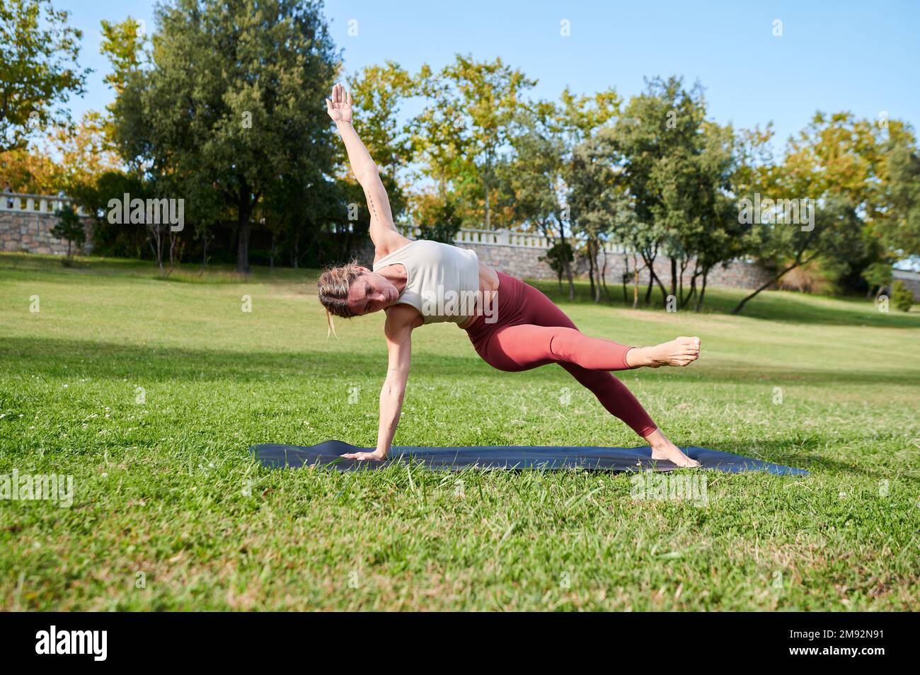 Full body of young fit female in tight activewear doing yoga exercise ...