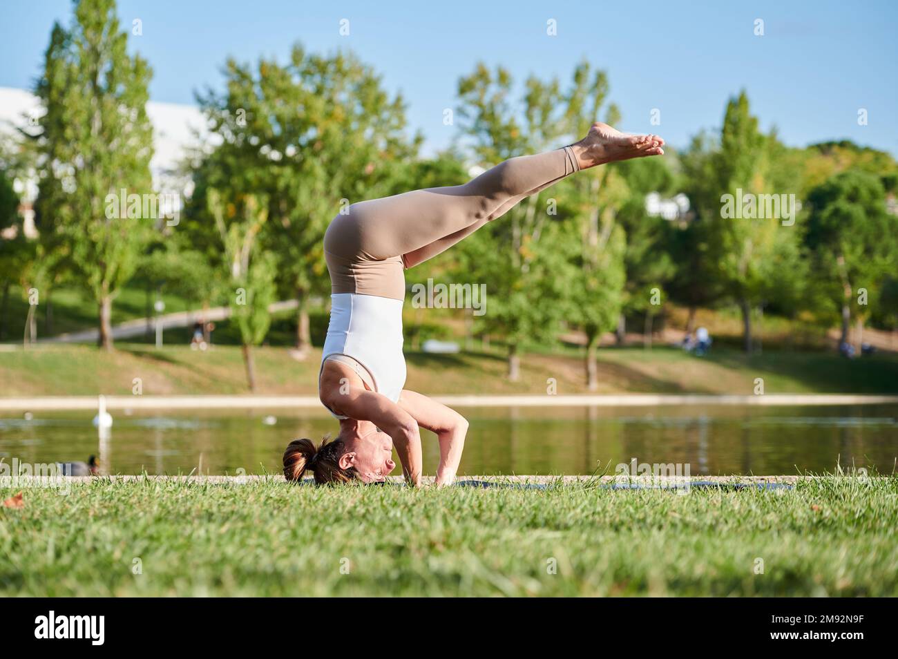 Full body side view of sporty female in activewear doing Mukta Hasta ...