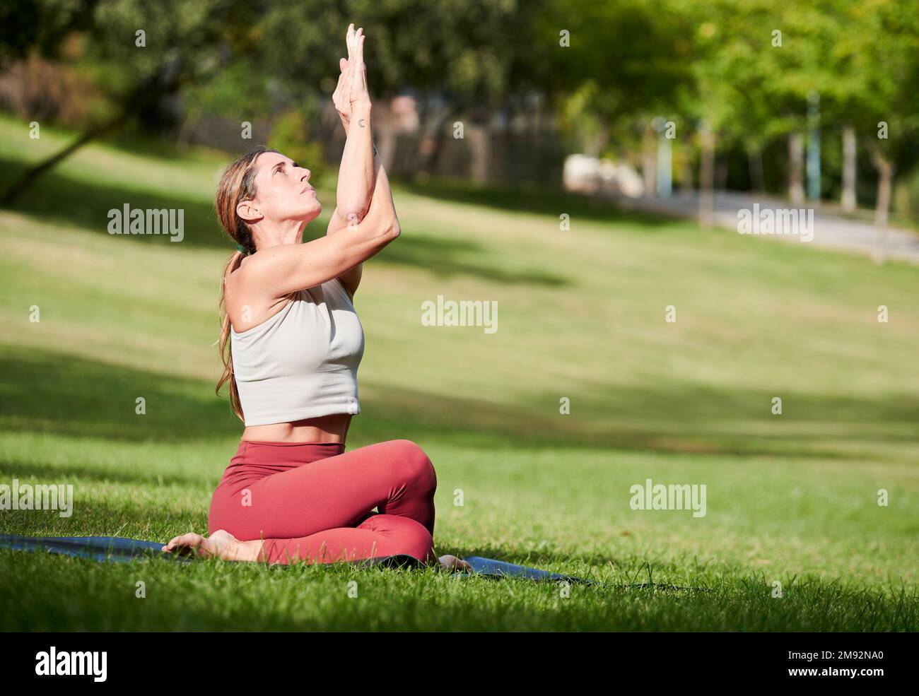 Full body of fit female athlete in sportswear sitting on mat while ...