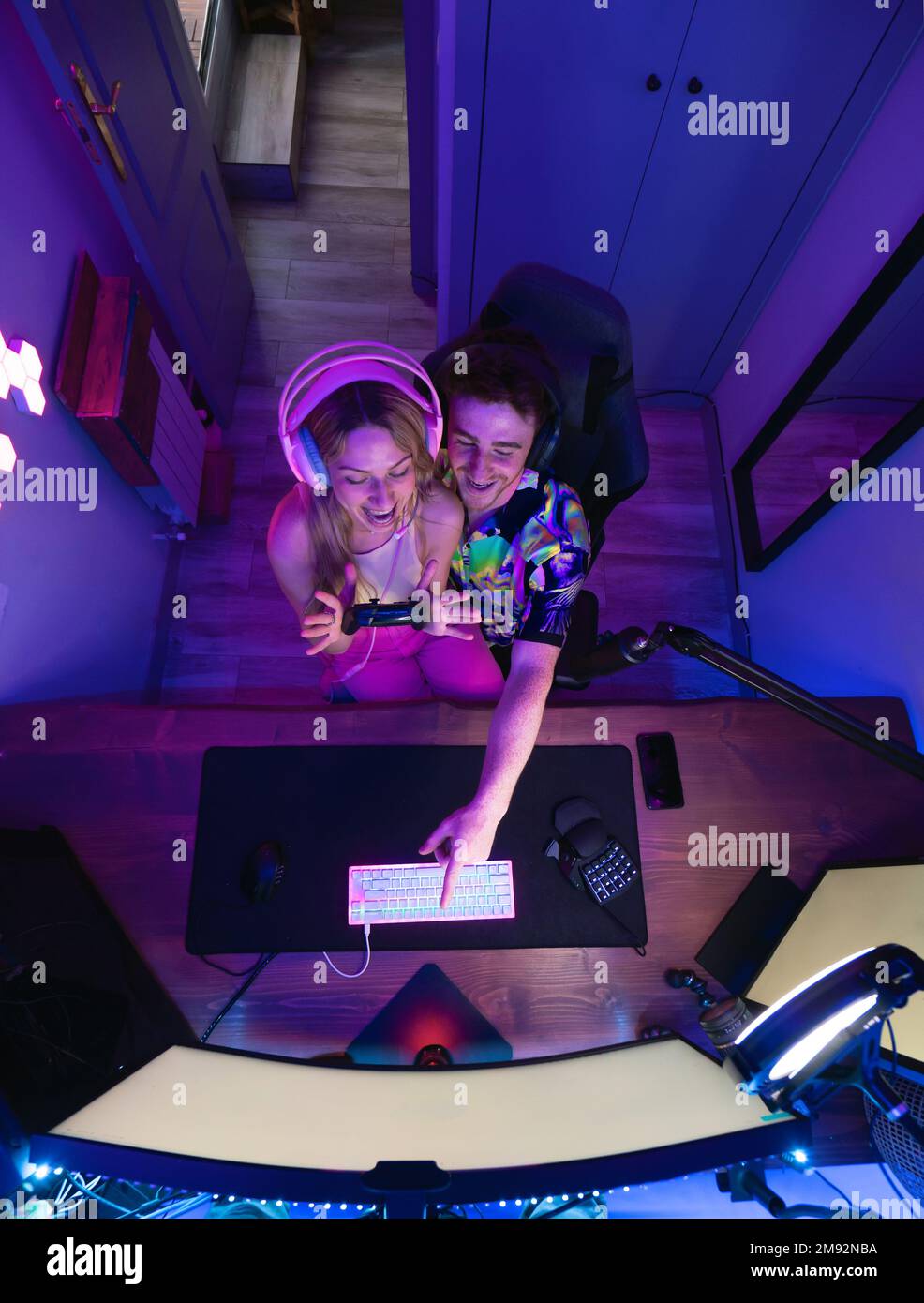 Top view of cheerful young blonde girlfriend sitting on boyfriend knees ...