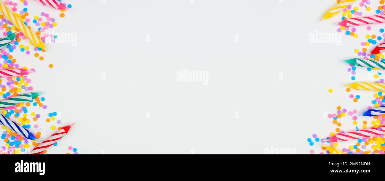 Colorful birthday cake candles with candy sprinkles. Overhead view banner with double border on ...