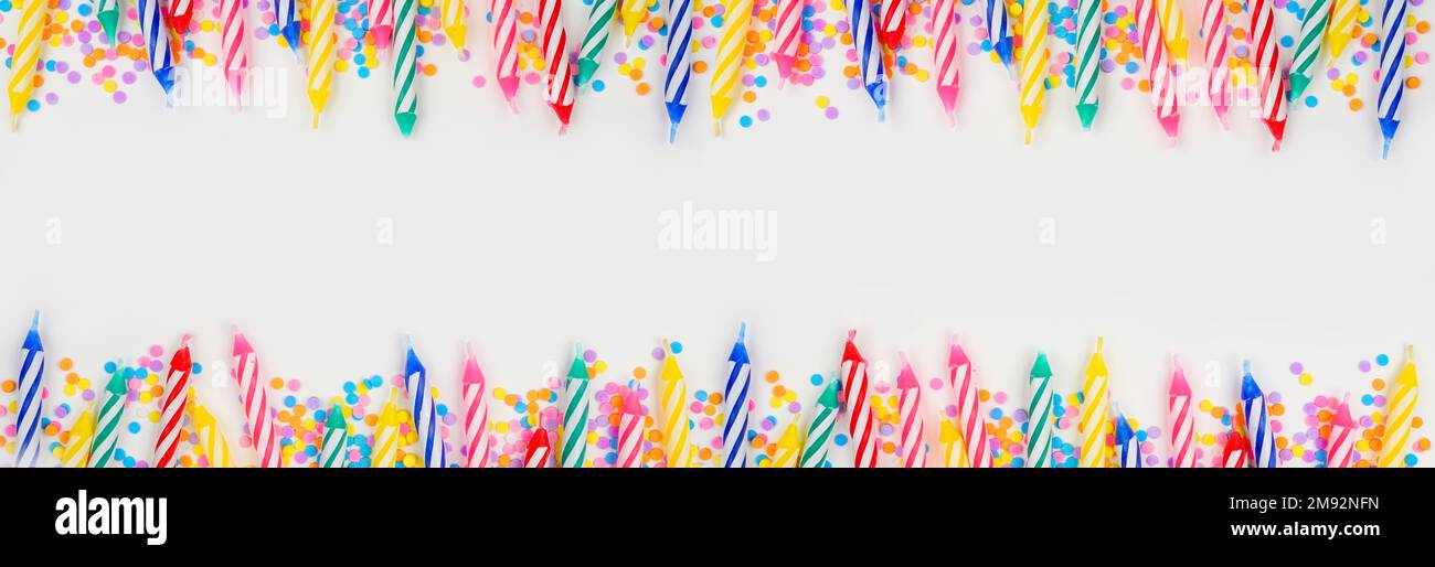 Colorful birthday cake candles with candy sprinkles. Top view banner ...