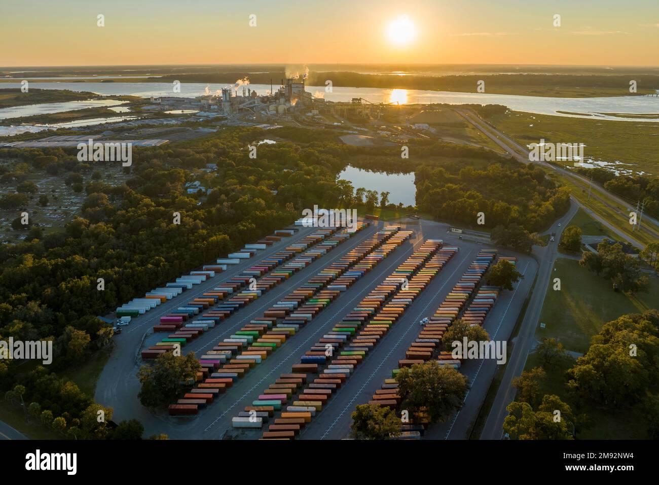 Large cargo container yard with many freight containers and big factory ...