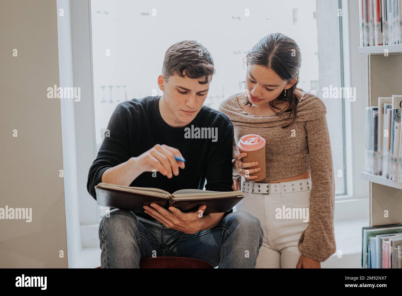 Concentrated young students in casual clothes reading notes while ...